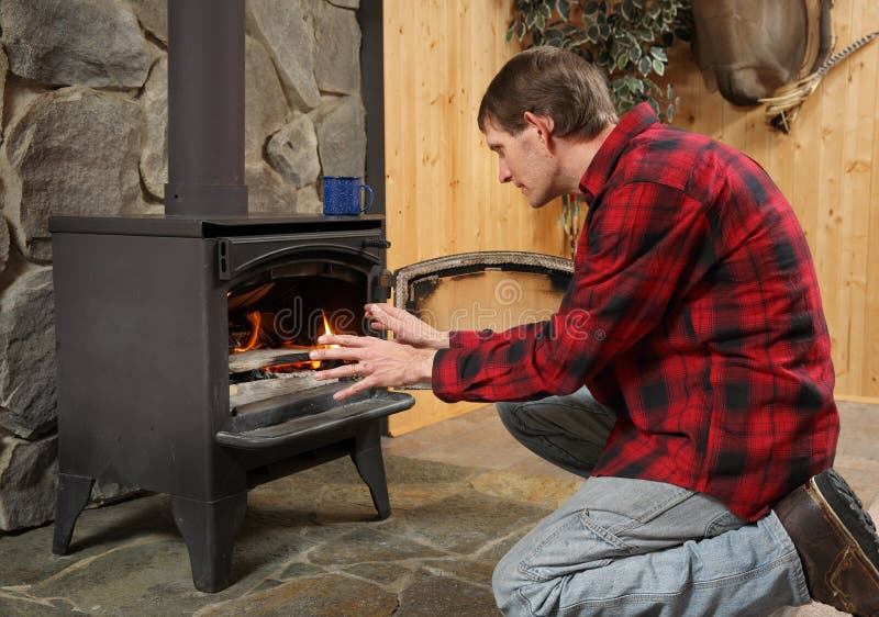 Man Loading Firewood in Woodburning Stove Stock Photo - Image of ...