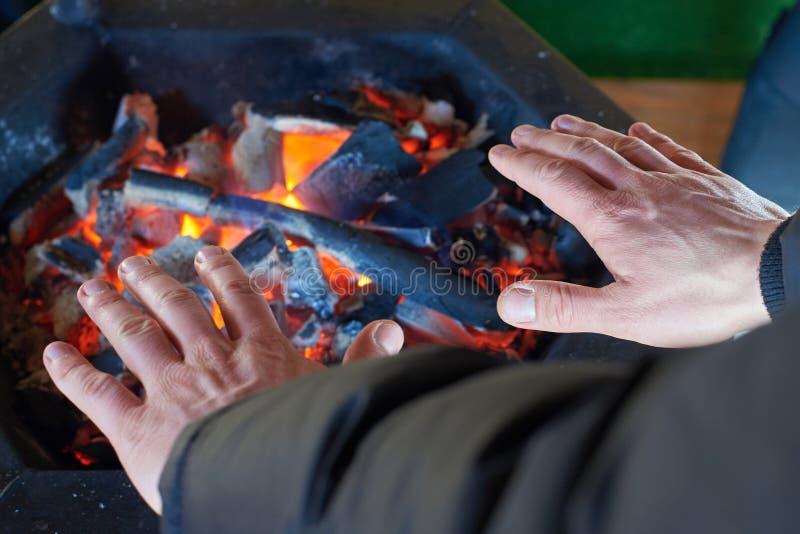 A Man is Warming His Hands on Glowing Coals Stock Photo - Image of ...