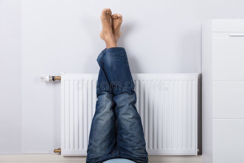 Man Warming Up His Feet on White Radiator Stock Photo - Image of ...