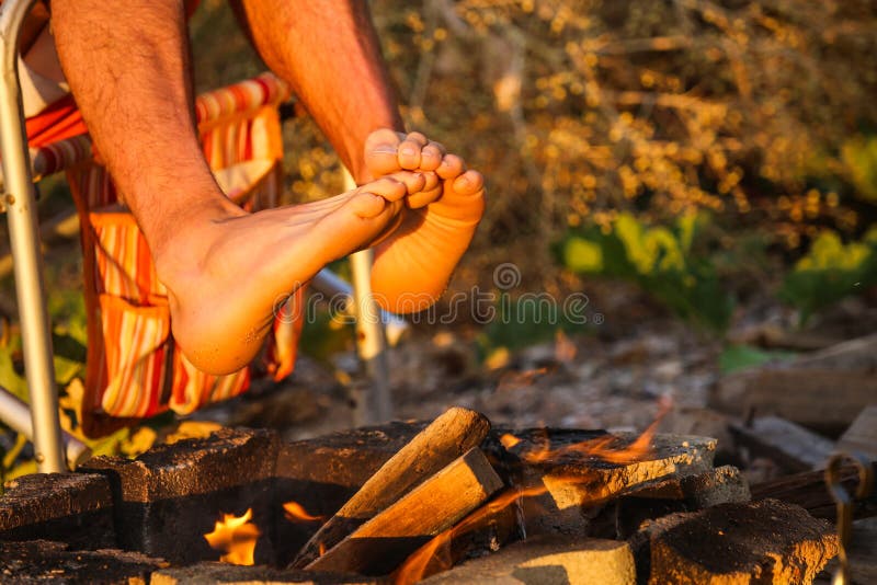 Man Warms His Bare Feet Over the Fire of BBQ Stock Photo - Image of ...
