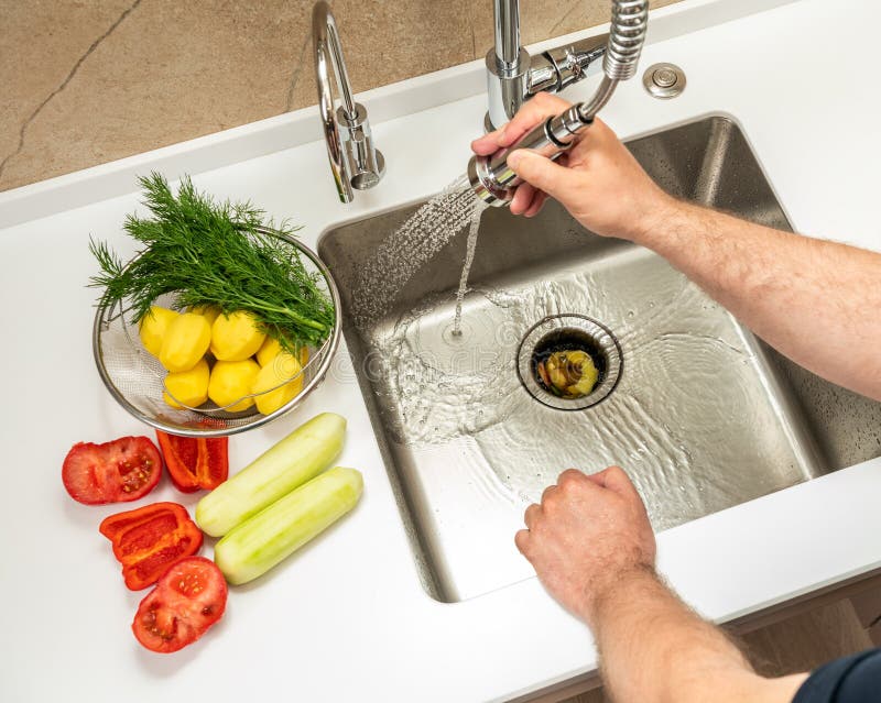 A Man Washes Food Waste into a Dispenser Stock Photo - Image of ...