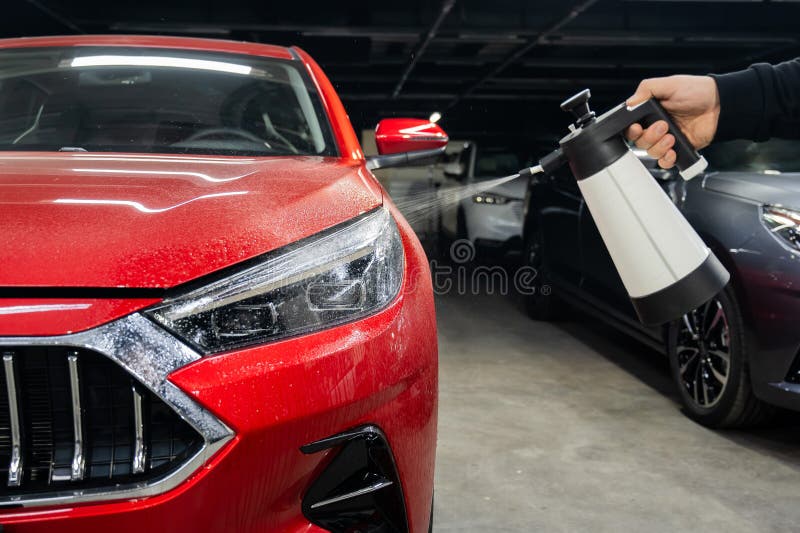 A Man Washes the Headlights of a Red Car with a Spray. Stock Photo ...