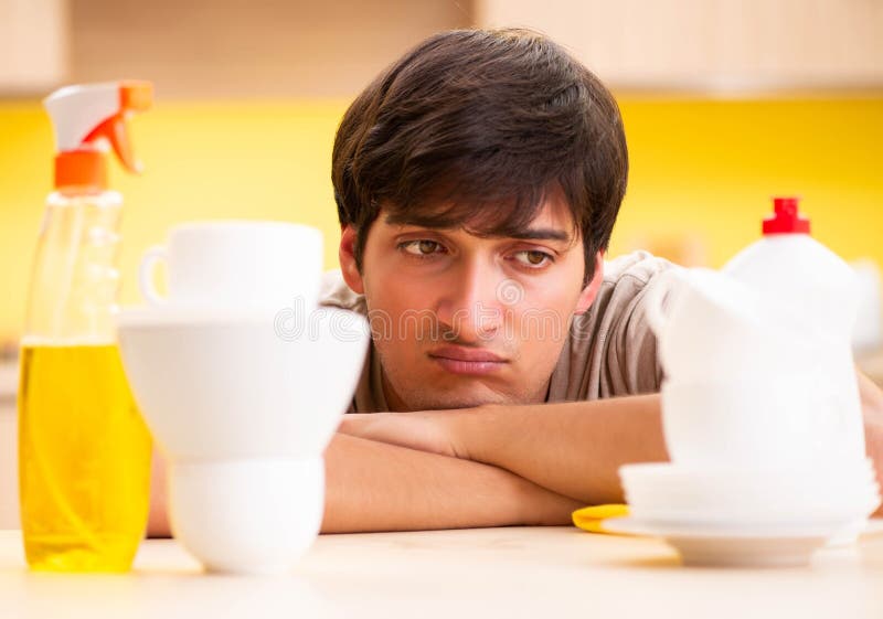 Man washing dishes at home stock photo. Image of housework - 179704814