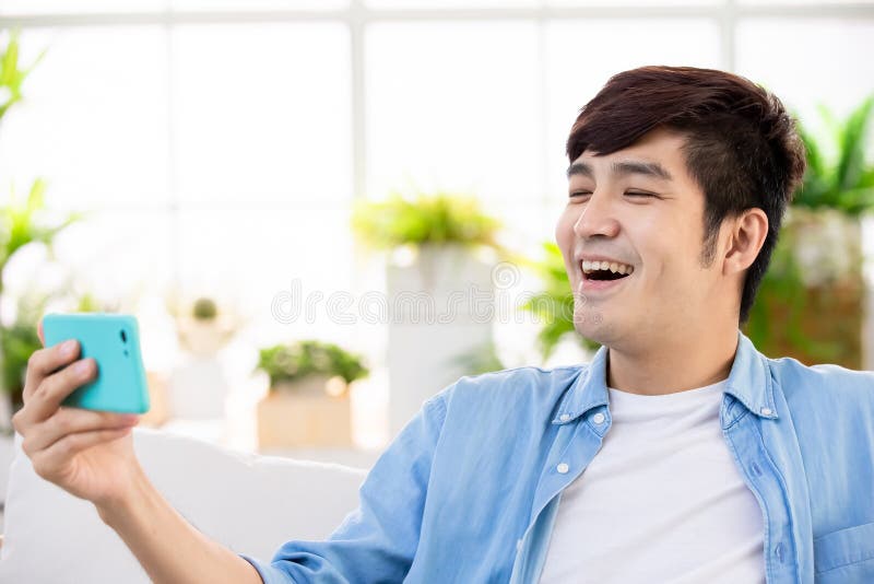 Man watch video with phone stock image. Image of couch - 145633019