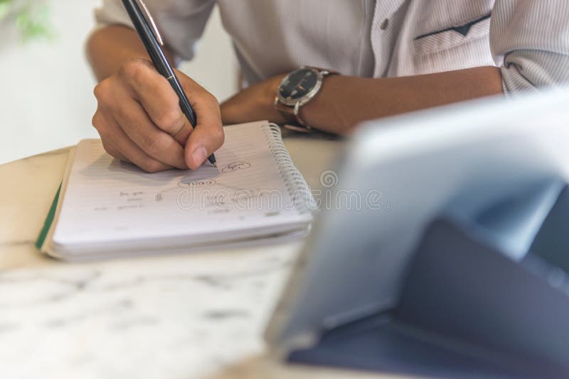 Man Watching Information on Tablet and Writing Notes Stock Image ...