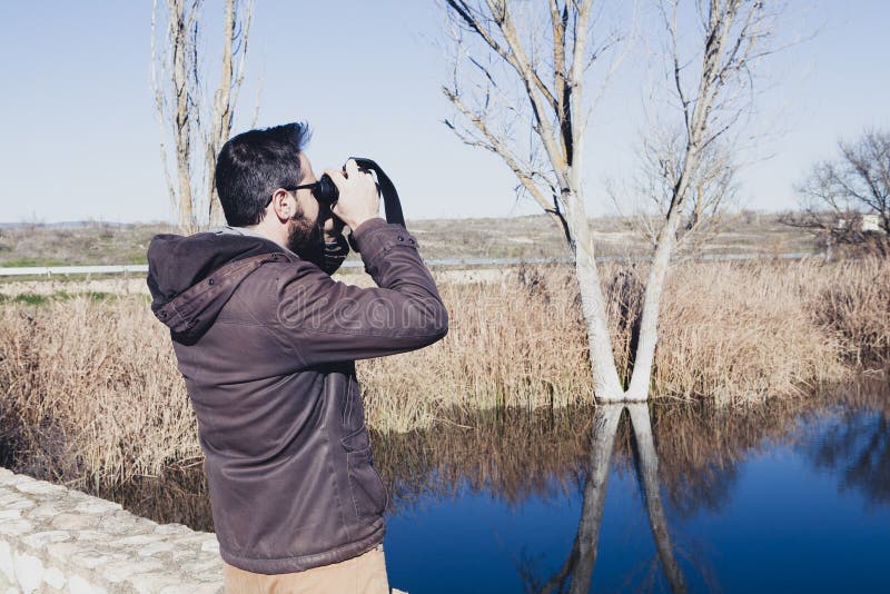 Man Watching Nature with Binoculars Next To the River. Stock Photo ...