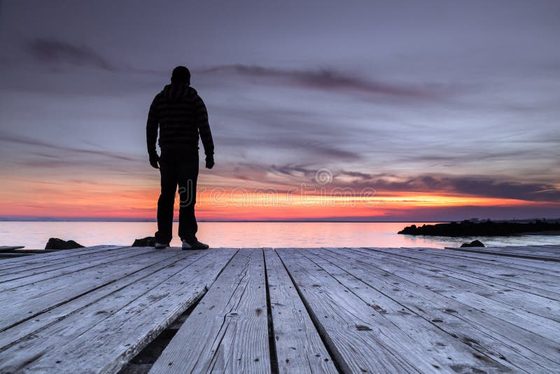 Man Sitting on the Pier and Watching the Sunset Stock Image - Image of ...