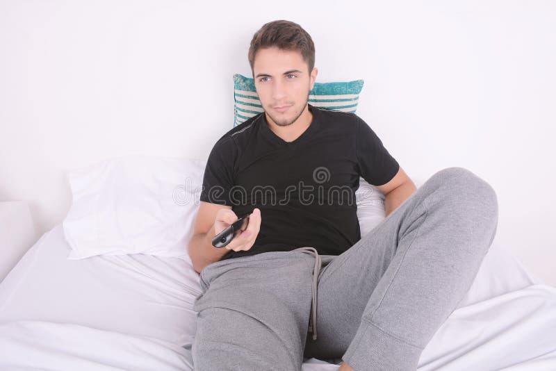 Man watching tv on bed. stock image. Image of comfortable - 100133067