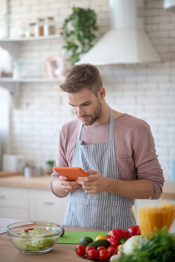 Man Watching Video on Tablet and Cooking at the Weekend Stock Photo ...
