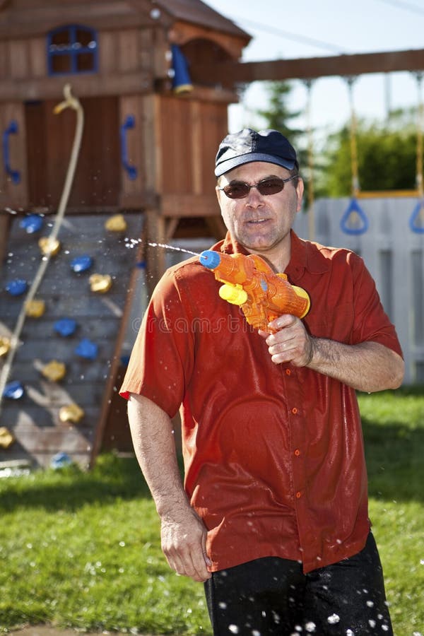Man in a water gun fight stock image. Image of mature - 22107919