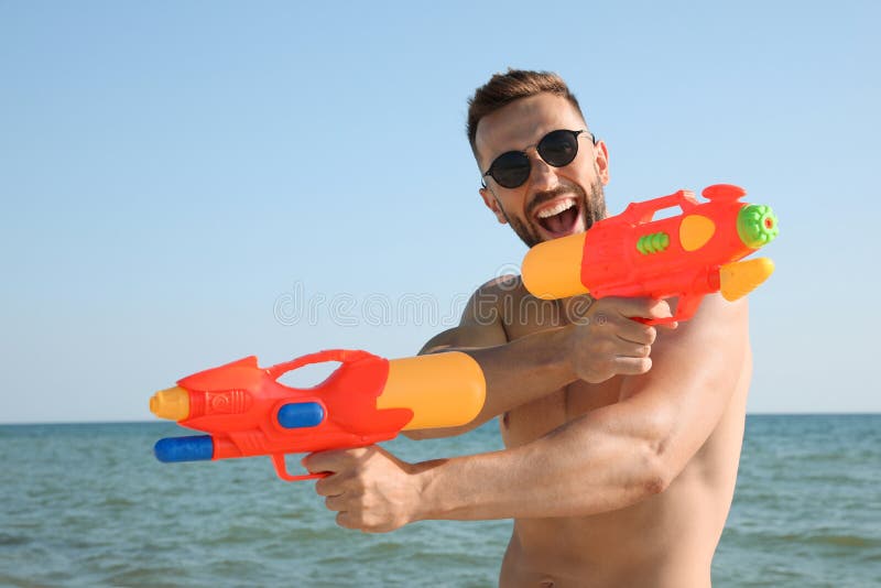 Man with Water Guns Having Fun on Beach Stock Photo - Image of nature ...
