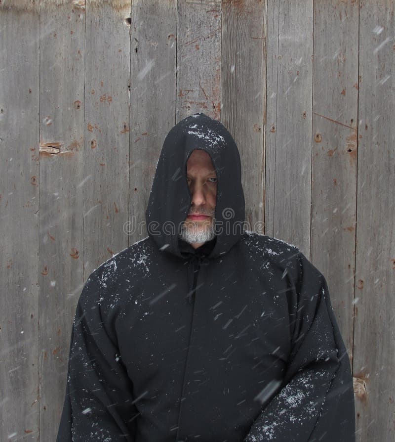 Man Wearing a Black Hooded Cape with Snow Falling Down Stock Photo ...