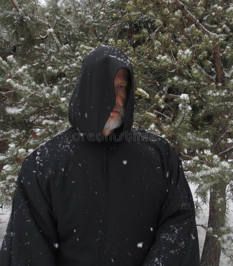Man Wearing a Black Hooded Cape with Snow Falling Down Stock Photo ...