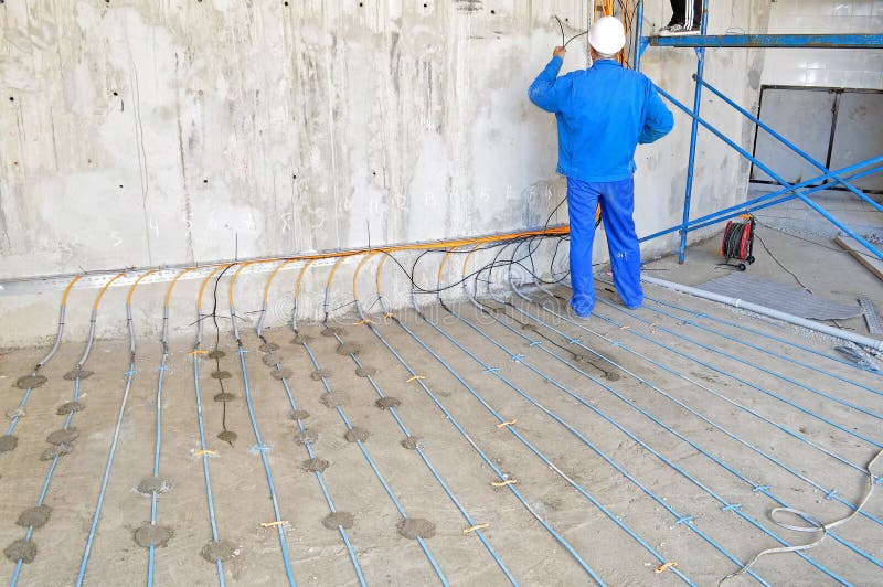 A Man Wearing a Blue Uniform is Seen Installing an Underfloor Heating ...
