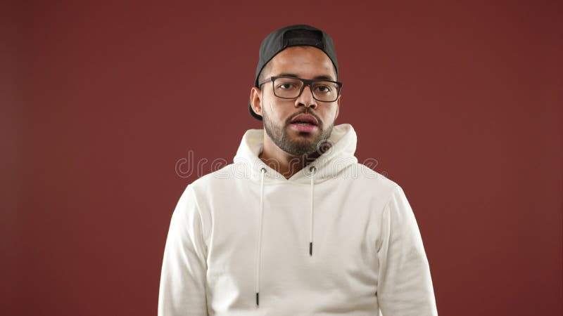 Man Assertively Gesturing Stop with Hand in a White Hoodie and Cap ...