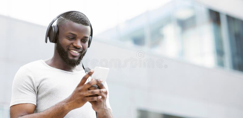 Man Using Smartphone while Wearing Headphones Outdoors Stock Image ...