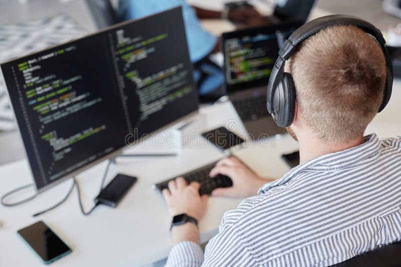 Man Wearing Headphones Working on Computer Programming Stock Image ...