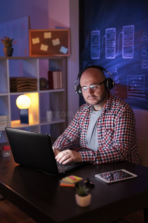 Man Wearing Headset Working on Laptop Computer Late at Night Stock ...
