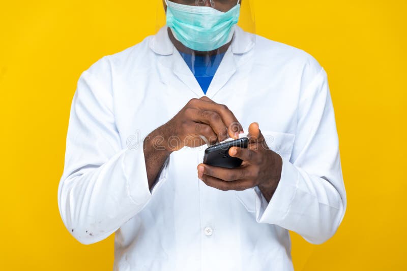 Man Wearing a Lab Coat, and Face Mask and Shield Cleaning the Surface ...