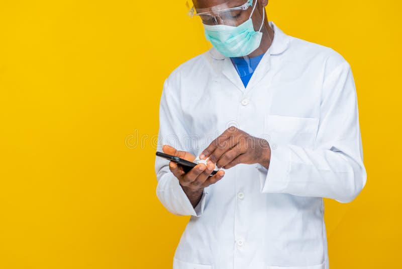 Man Wearing a Lab Coat, and Face Mask and Shield Cleaning the Surface ...