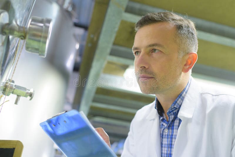 Man Wearing Labcoat Inspecting Vat and Holding Clipboard Stock Image ...