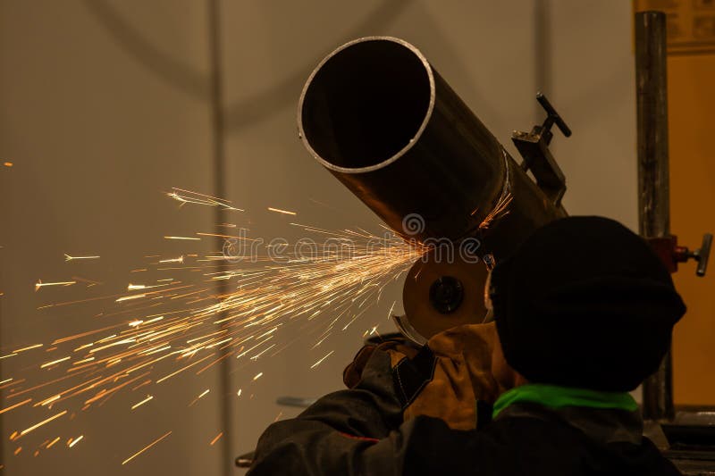 A Man Wearing a Protective Mask Welds a Metal Pipe. Stock Photo - Image ...