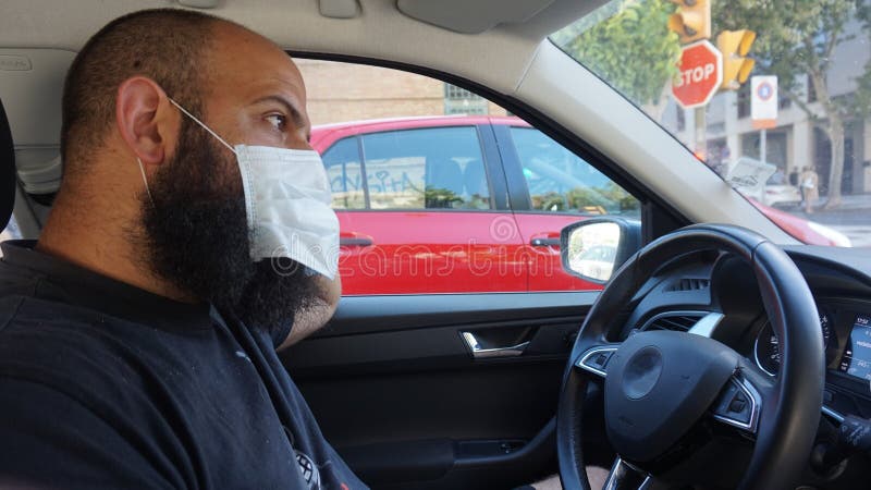 Man Wearing a Protective White Face Mask while Driving a Car Stock ...