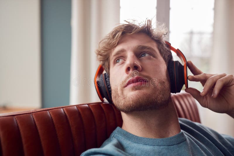 Man Wearing Wireless Headphones Listening To Music Relaxing On Armchair