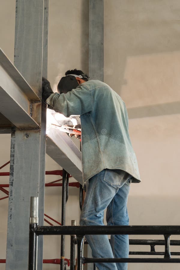 Man Weld a Metal with a Welding Machine. Stock Image - Image of ...