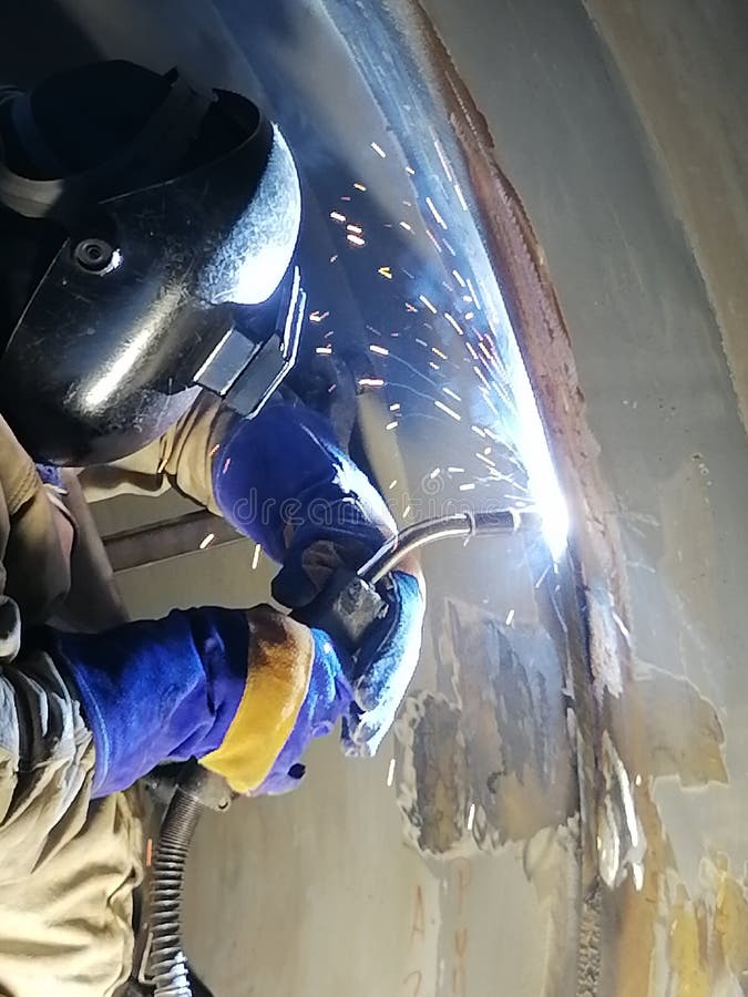 Man Welding inside a pipe stock photo. Image of costume - 219907984