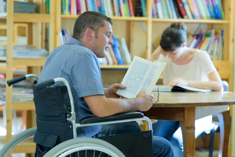 Man in Wheelchair Reading Book in Library Stock Image - Image of ...