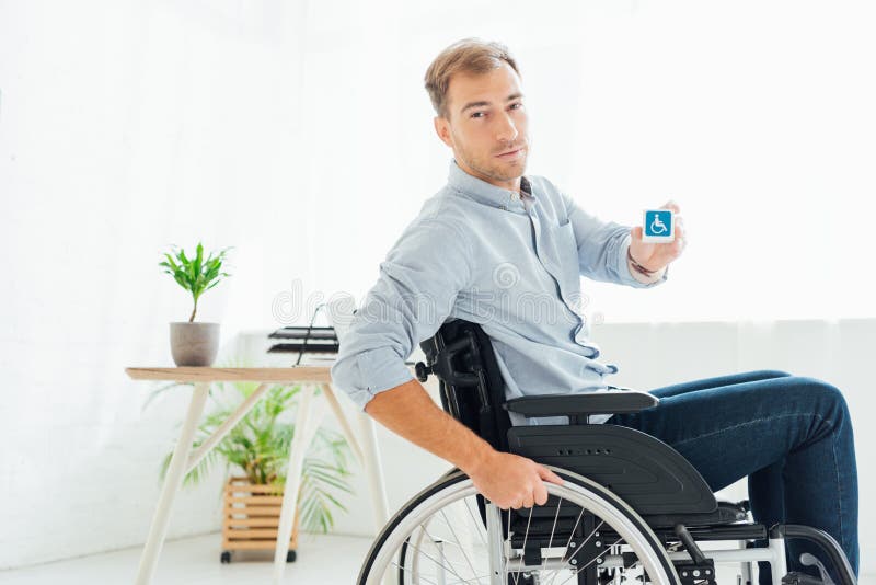 Man In Wheelchair Showing Cube With Disabled Sign Stock Photo - Image ...