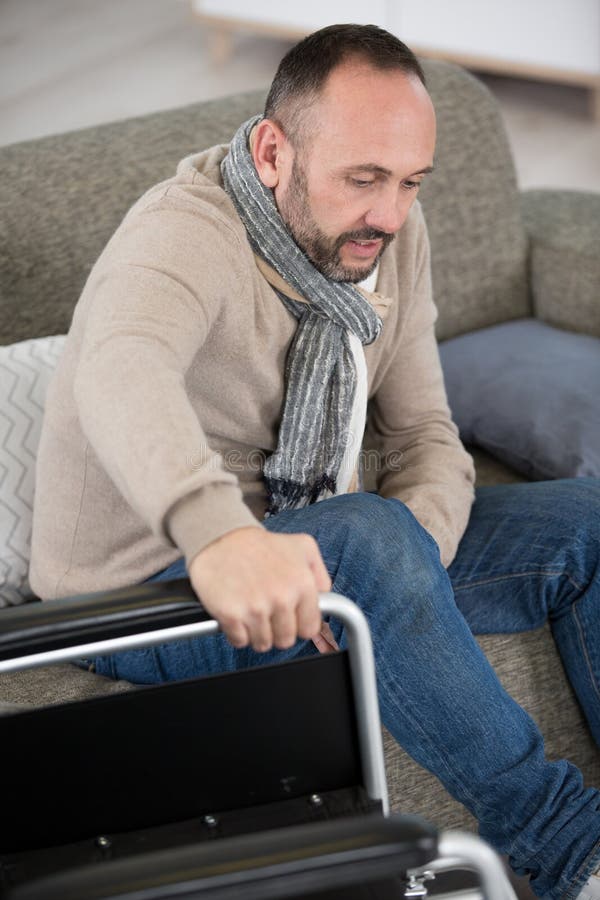 Man in Wheelchair Sitting To Sofa Alone Stock Image - Image of ...