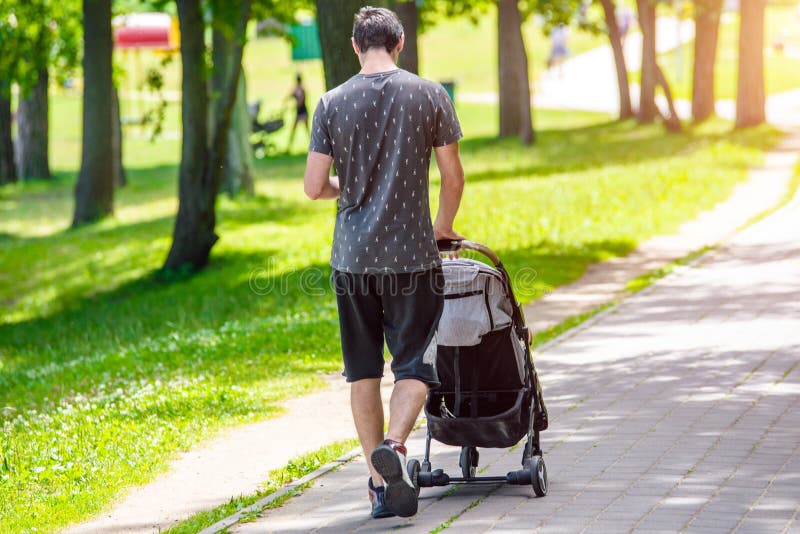 Man wheeling a pram stock photo. Image of walk, spring - 203123506