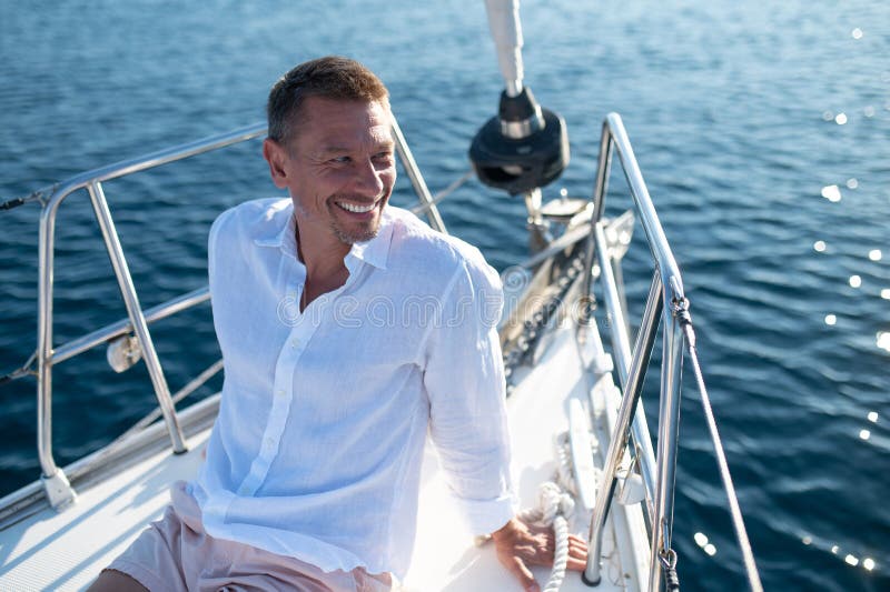 Man in White Clothes Sitting on a Yacht Deck and Looking Relaxed and ...