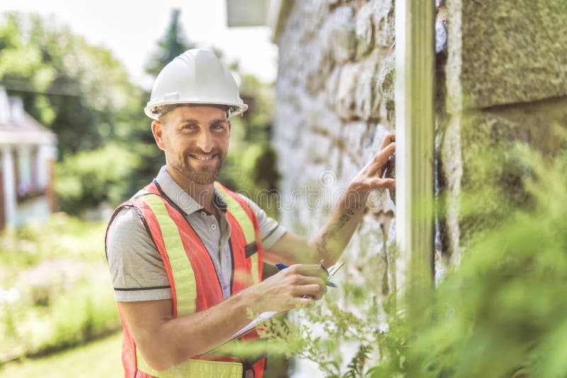 Man with a White Hard Hat Holding a Clipboard, Inspect House Stock ...