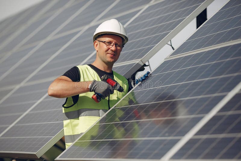 Man in a White Helmet Near a Solar Panel Stock Image - Image of ...