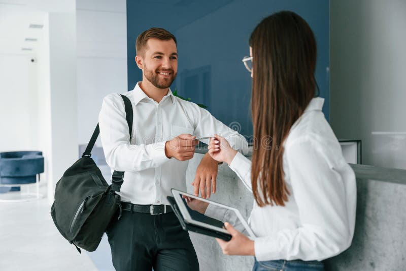Man in White Shirt is Ordering a Room in the Hotel by Woman S Help ...