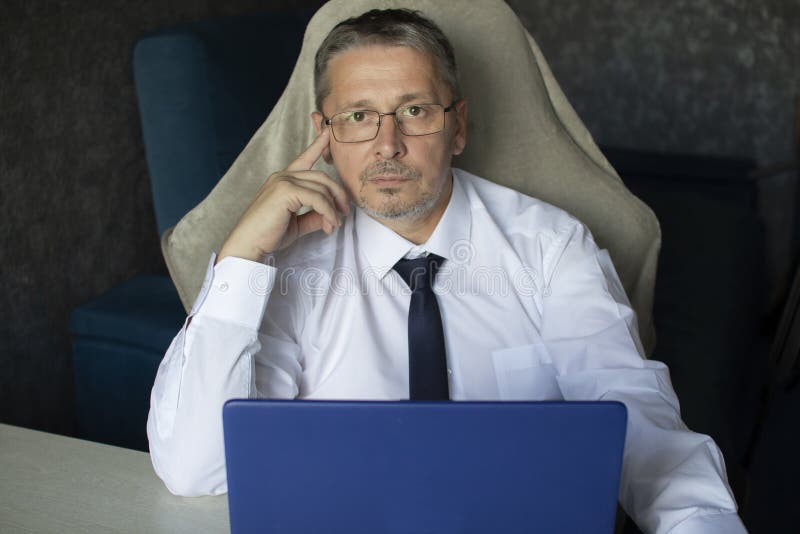 A Man in a White Shirt is Working at Home on a Laptop. Remote Work ...