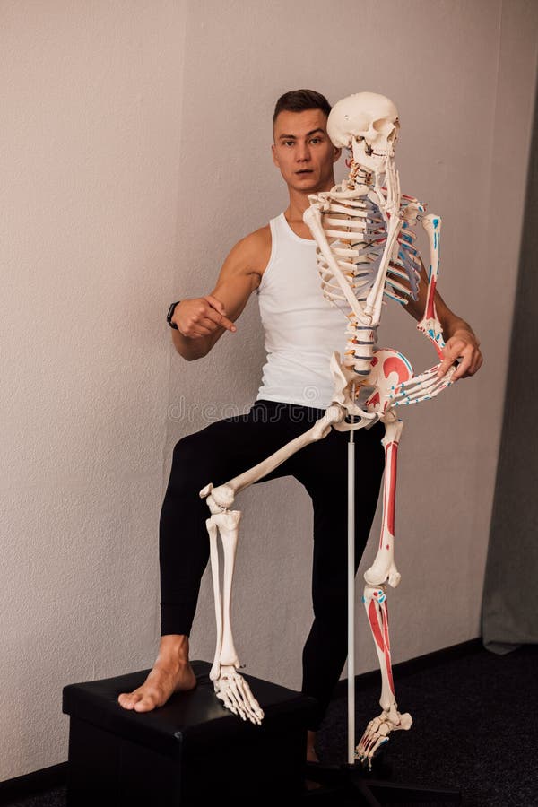 A Man in a White T-shirt Studies the Structure of the Human Skeleton ...