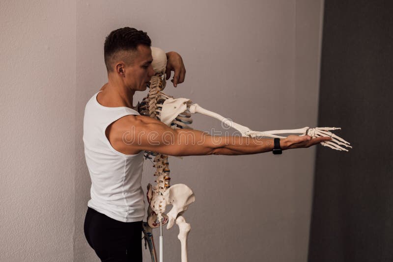 A Man in a White T-shirt Studies the Structure of the Human Skeleton ...