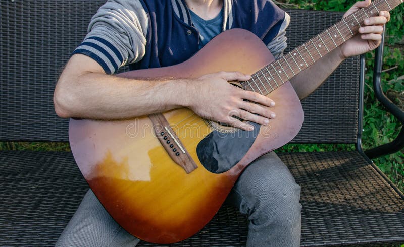A Man, Whose Face is Not Visible, Plays the Guitar on a Musical ...