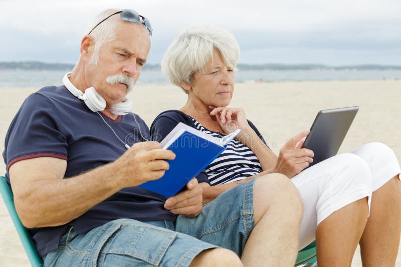 Man and Wife Reading Book on Beach Stock Photo - Image of monument ...