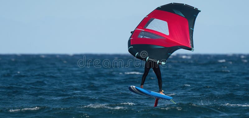 A Man is Wing Foiling Using Handheld Inflatable Wings and Hydrofoil ...