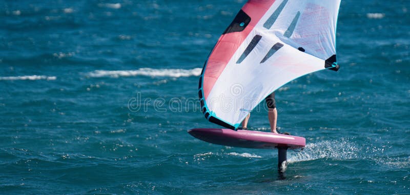 A Man is Wing Foiling Using Handheld Inflatable Wings and Hydrofoil ...
