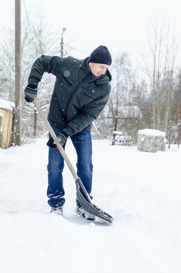 Man in Winter Clothes Clearing Snow from Path with Shovel. Winter Time ...