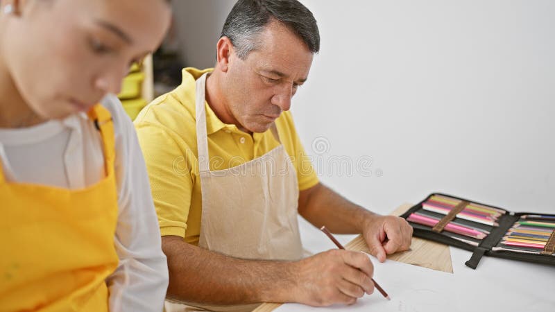 Man and Woman Artists, Deep in Concentration, Sitting Together in Art ...