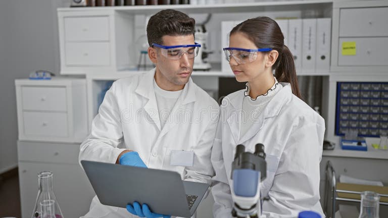 Man and Woman, As Scientists, Collaborate Using a Laptop in a Modern ...