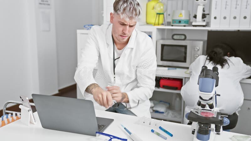 A Man and Woman, Both Scientists, Work Together in a Laboratory Setting ...