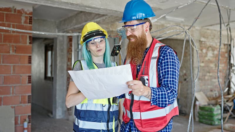 Man and Woman Builders Reading House Project Speaking at Construction ...